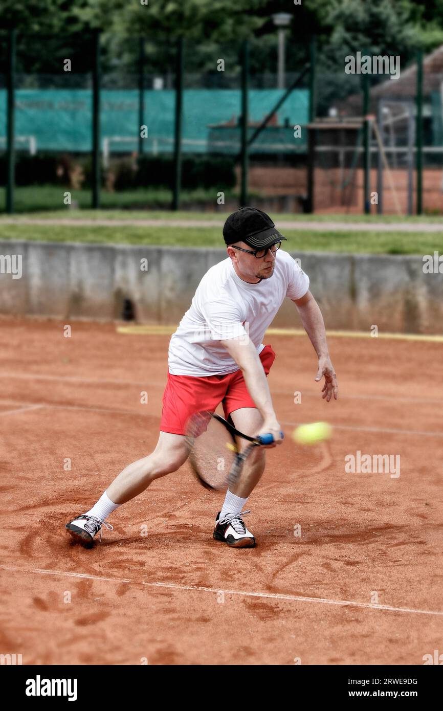 Tennis player plays deep forehand volley Stock Photo - Alamy