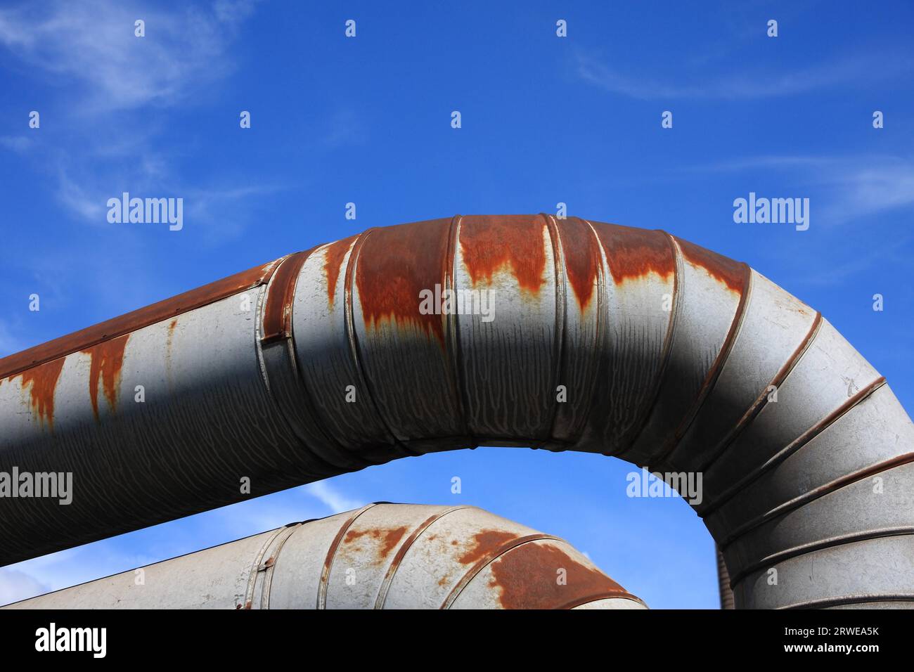 Two pipes, slightly rusty, background blue sky Stock Photo - Alamy
