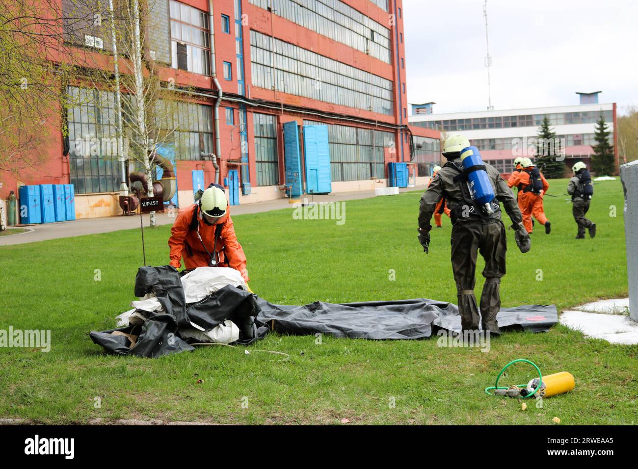 Professional firefighters, rescuers in protective fireproof suits ...