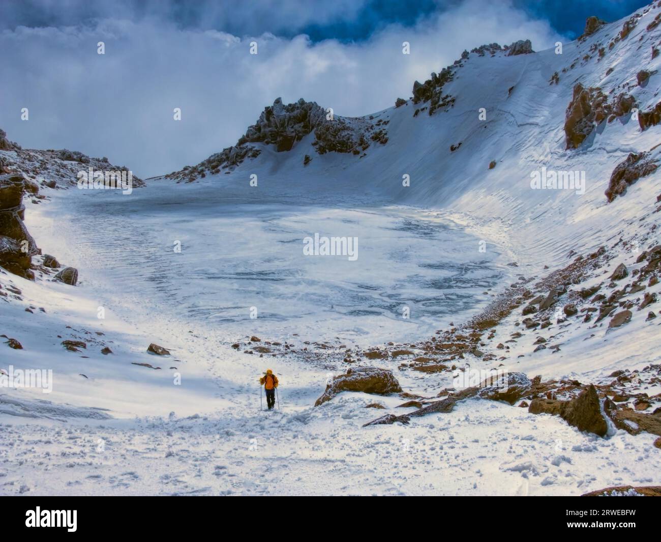 Hiker in crater with frozen lake on Sabalan, volcano in north Iran ...