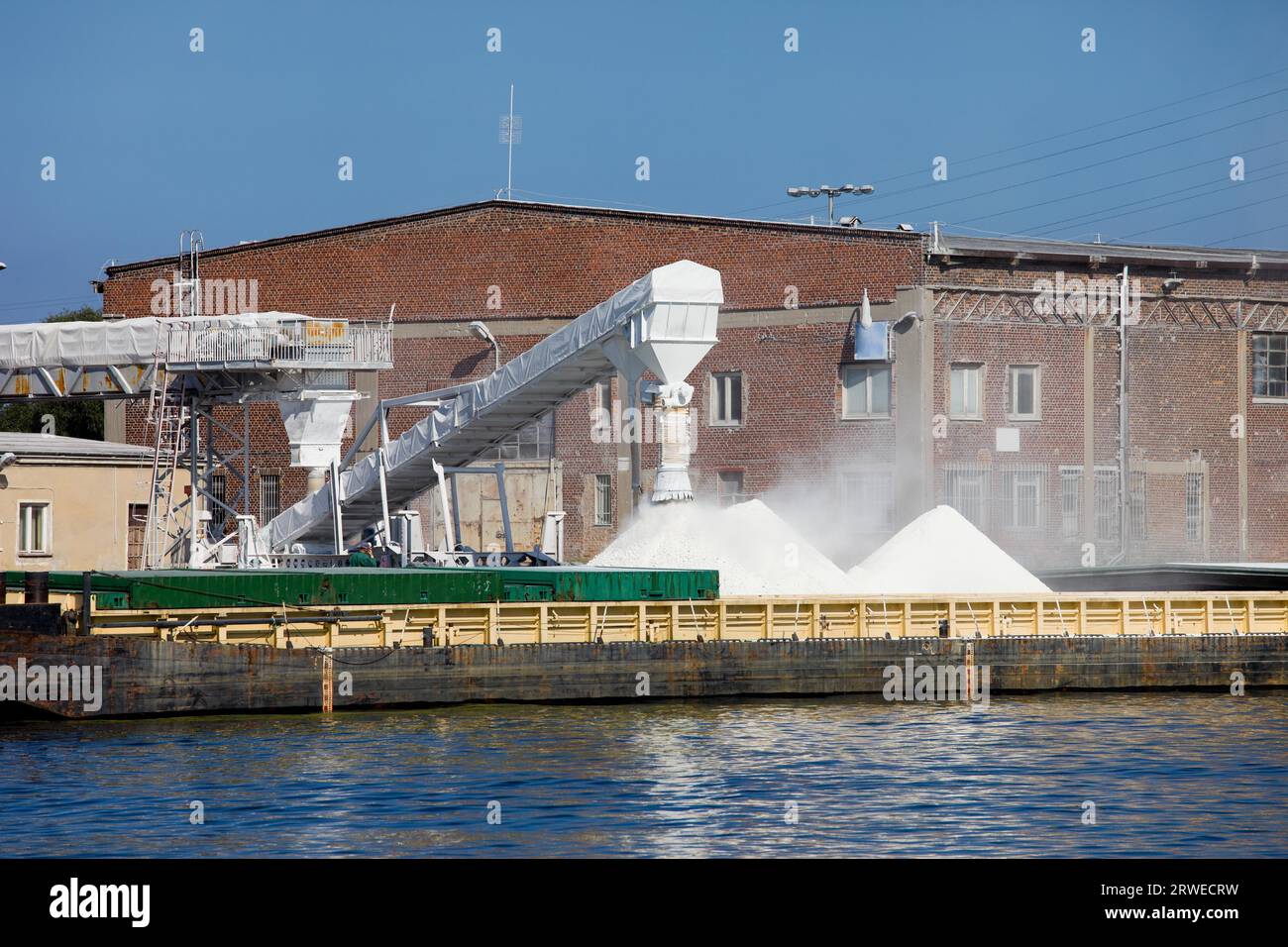 Piles of fresh salt waiting for transportation at river waterfront ...