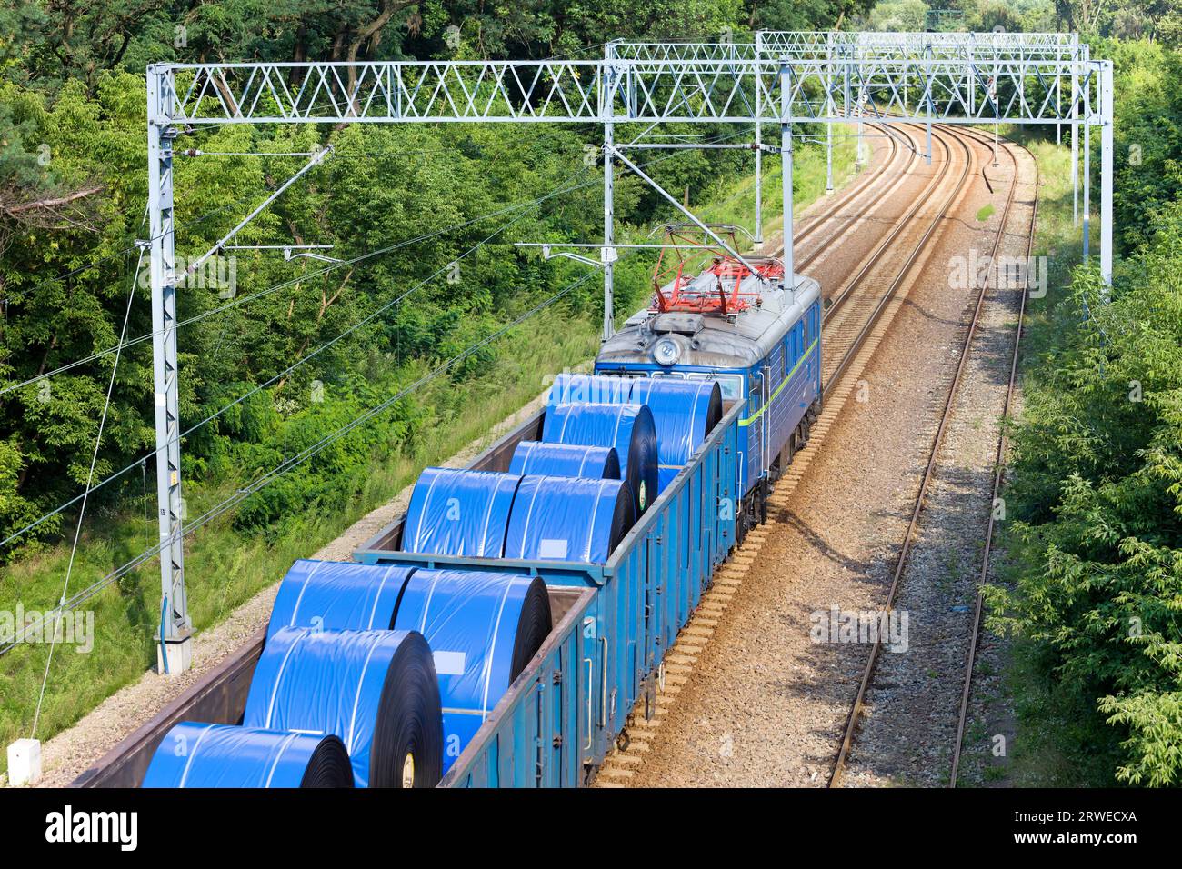 Goods train with an open top wagons loaded with cargo going through the ...