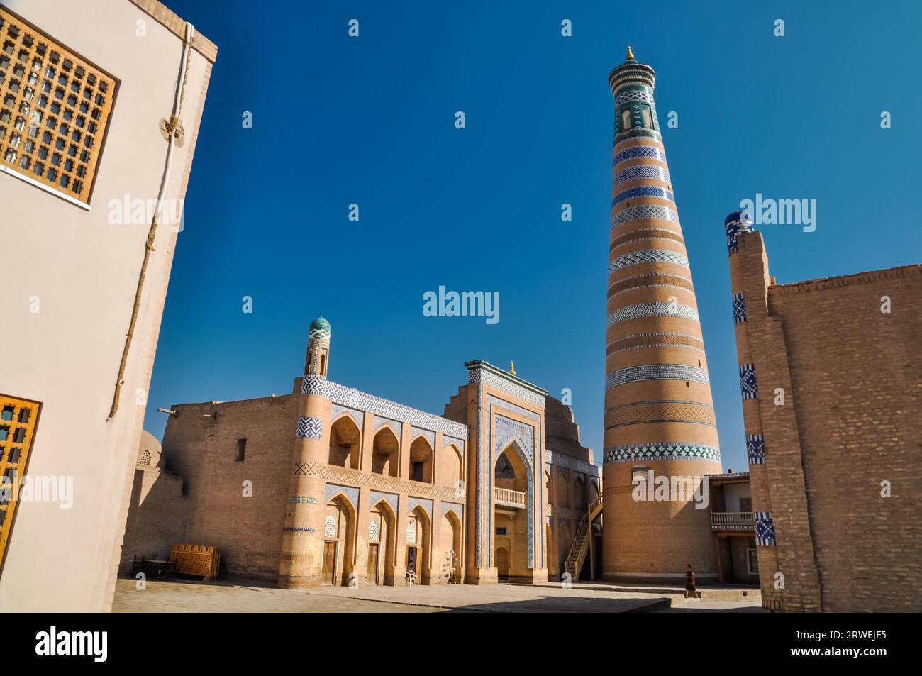 Houses and large tower made of bricks with blue ornaments painted on ...