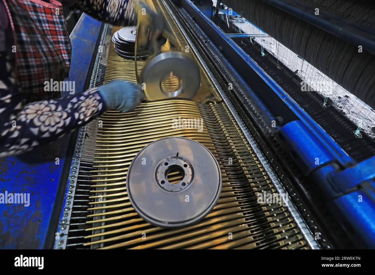 Workers replace shuttle cores at a fishing net processing plant, China ...