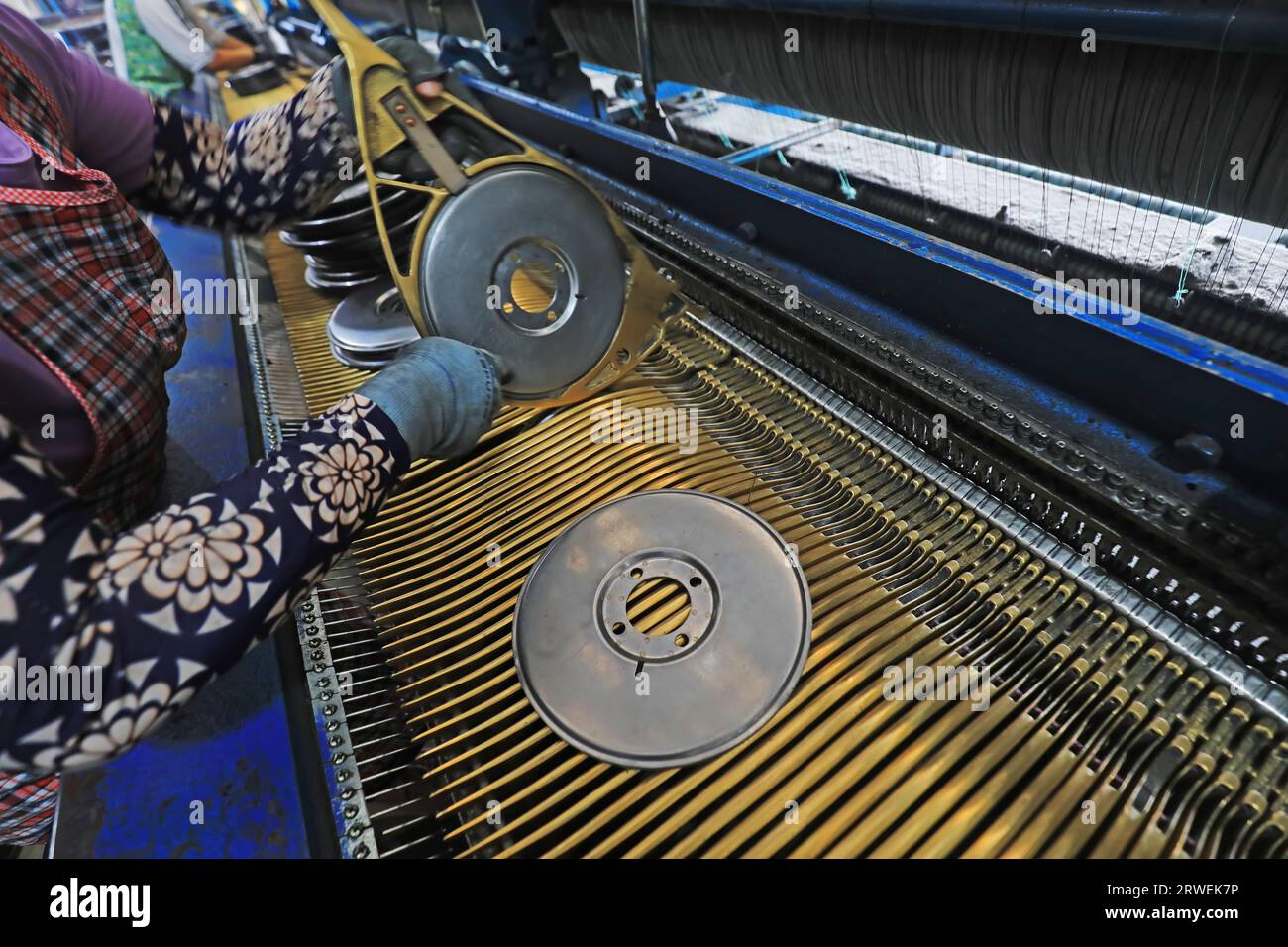 Workers replace shuttle cores at a fishing net processing plant, China ...