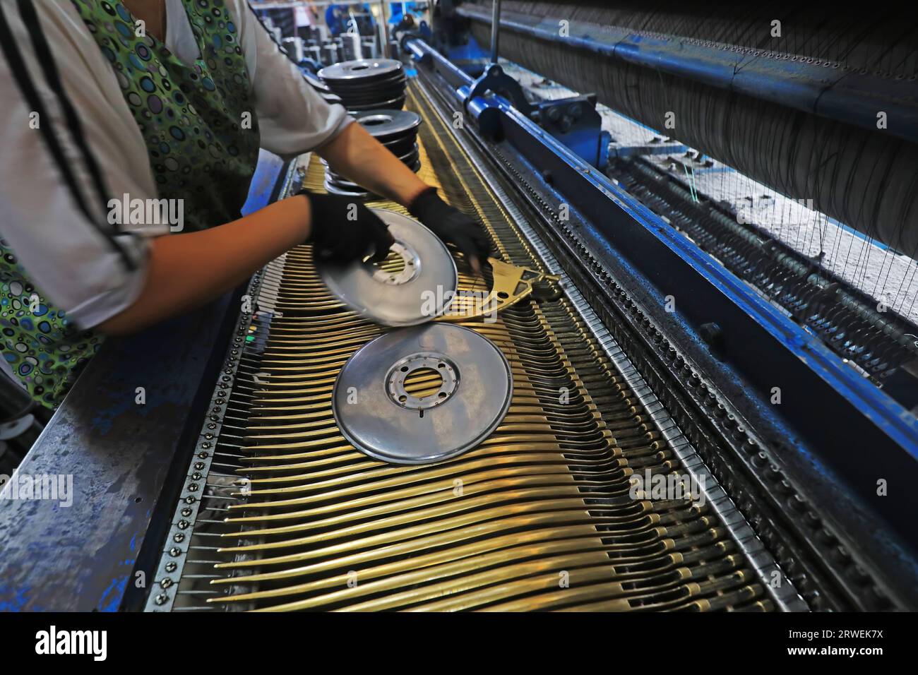 Workers replace shuttle cores at a fishing net processing plant, China ...