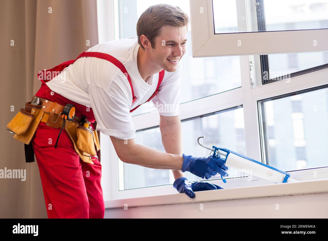 Construction worker installing window in house Stock Photo - Alamy