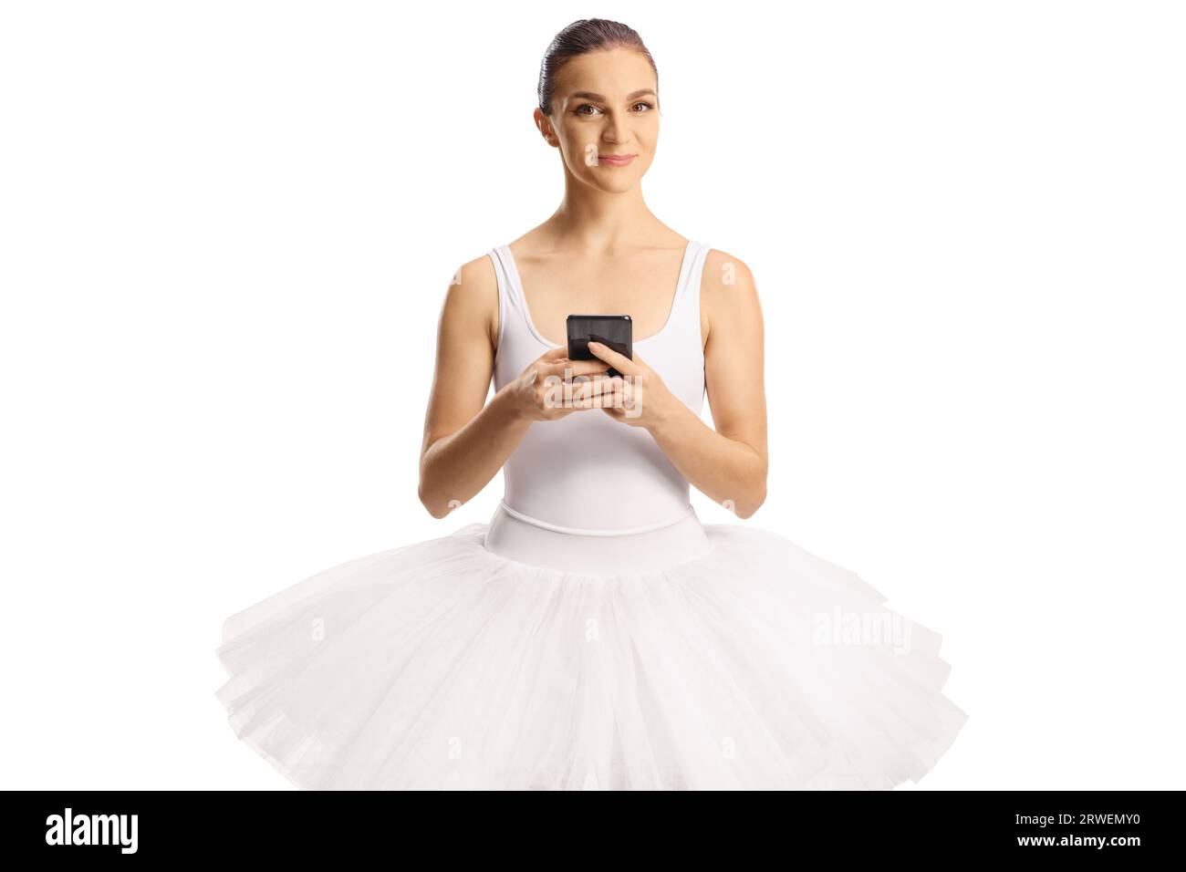 Ballerina in a white dress holding a smartphone and looking at camera ...