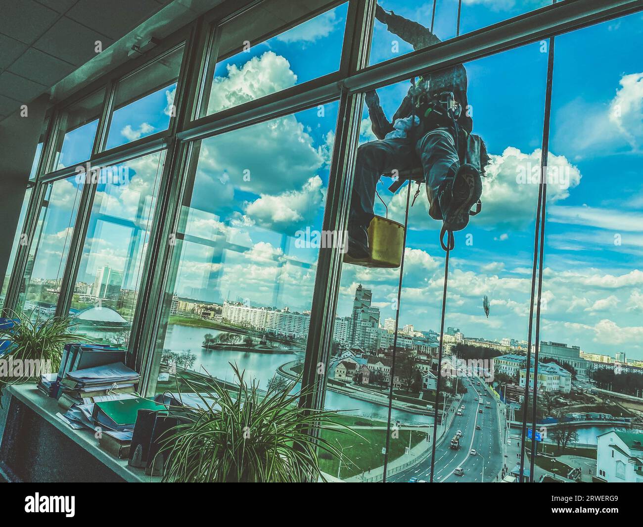 A maintenance workers cleaning windows on high rise building Stock ...