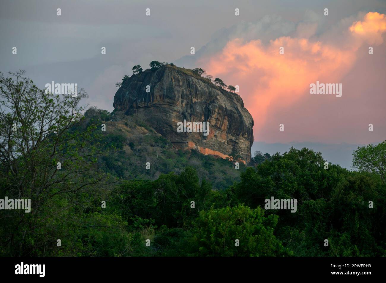 Sunset over Sigiriya Rock Fortress in central Sri Lanka. The rock is a ...