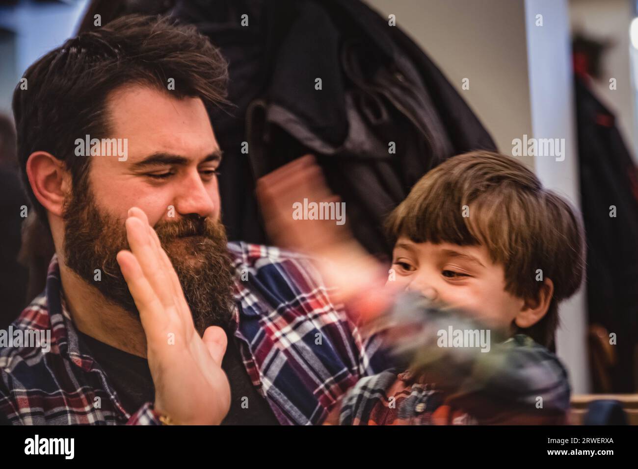 Relaxed guy with long beard and an excited boy exchange a high five ...