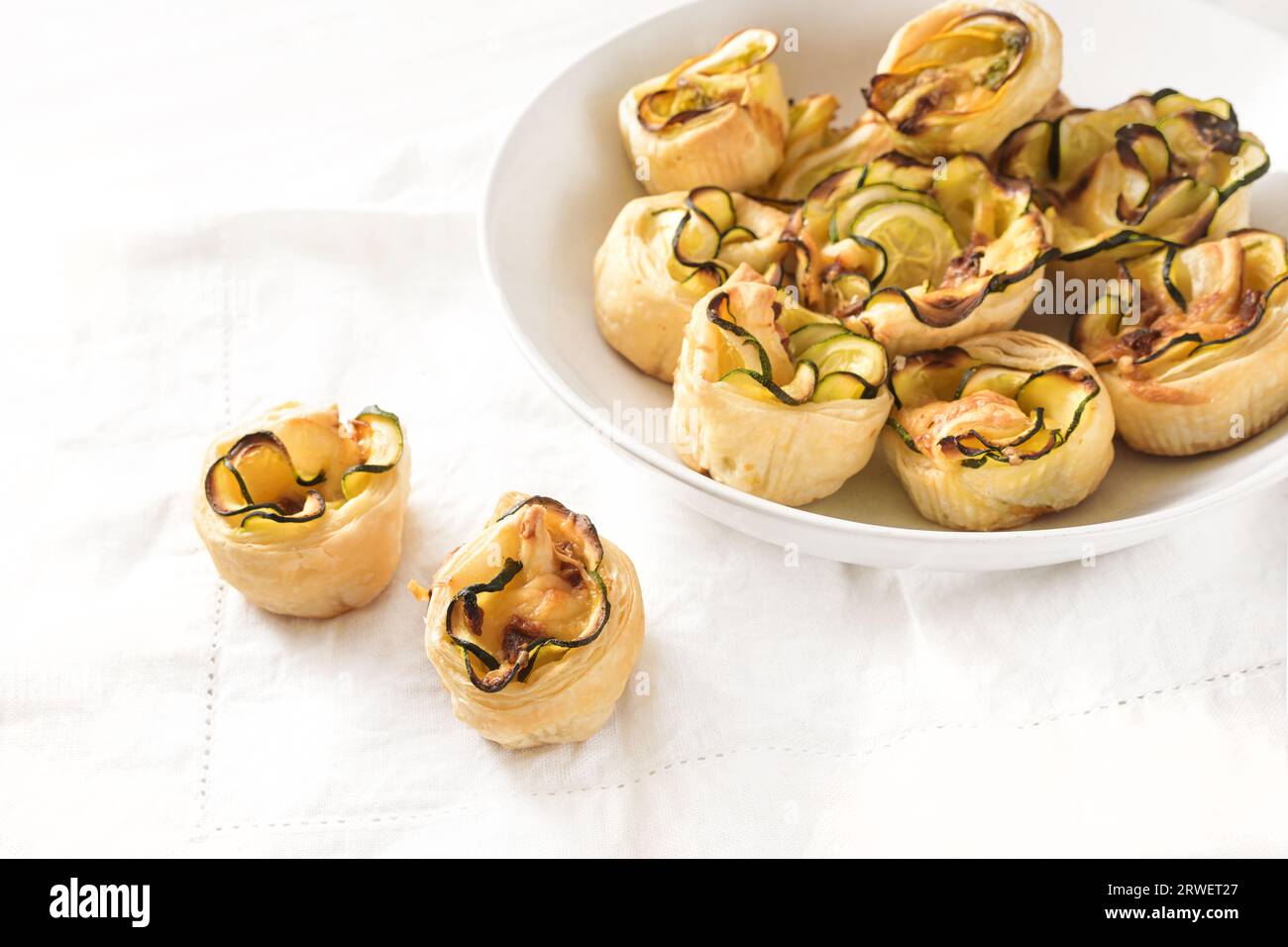 Puff pastry muffins rolled with zucchini slices, finger food in a white ...