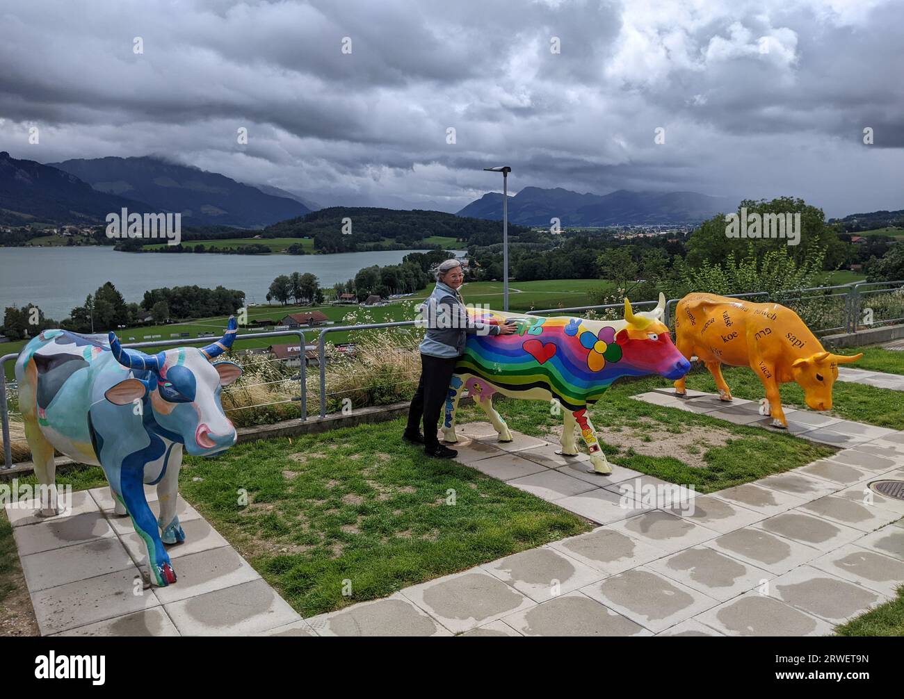 GRUYERE, SWITZERLAND - AUGUST 5, 2023: People posing with painted cows ...