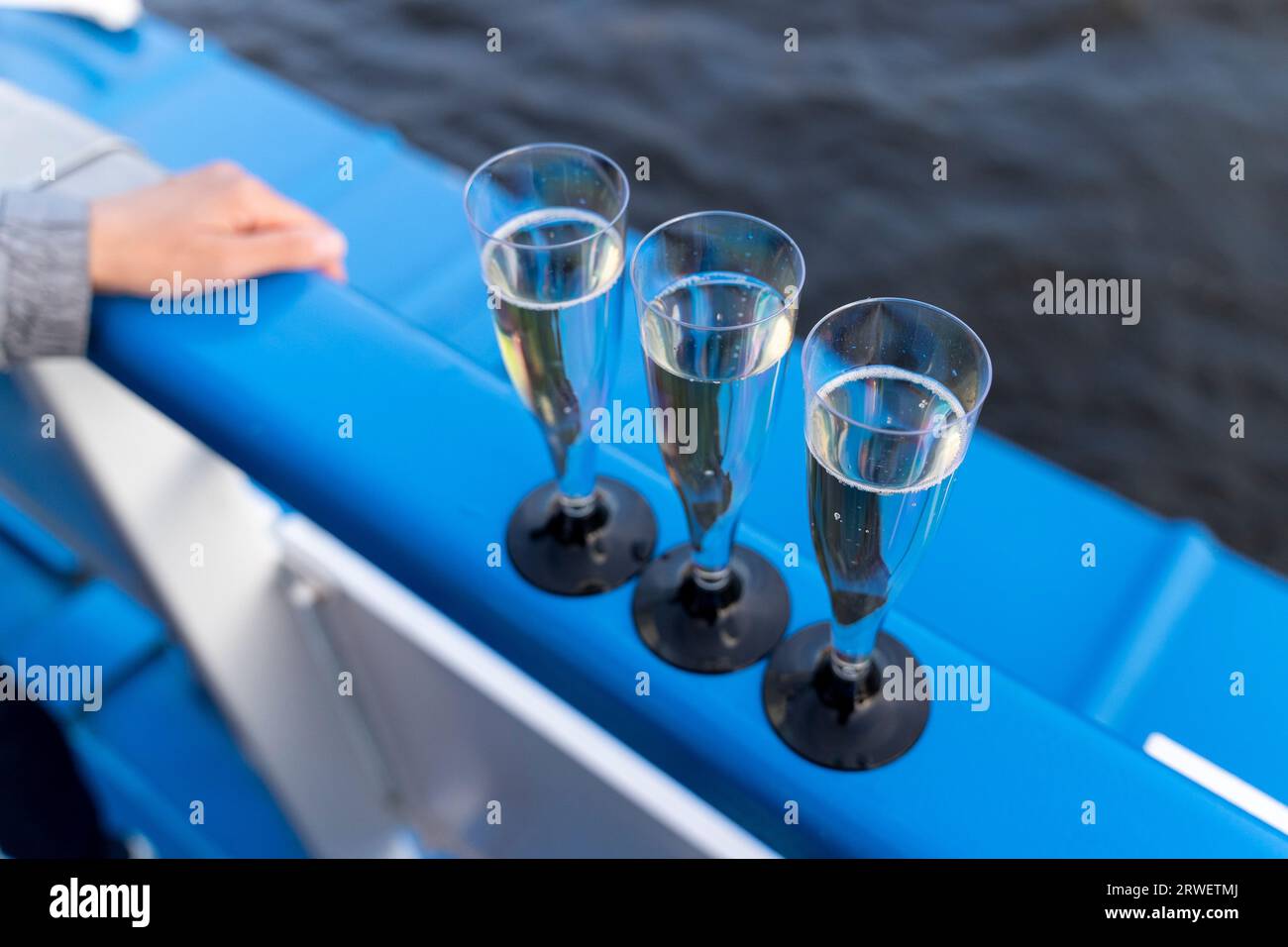 Champagne glasses are on the railing on board the ship. Close-up of ...