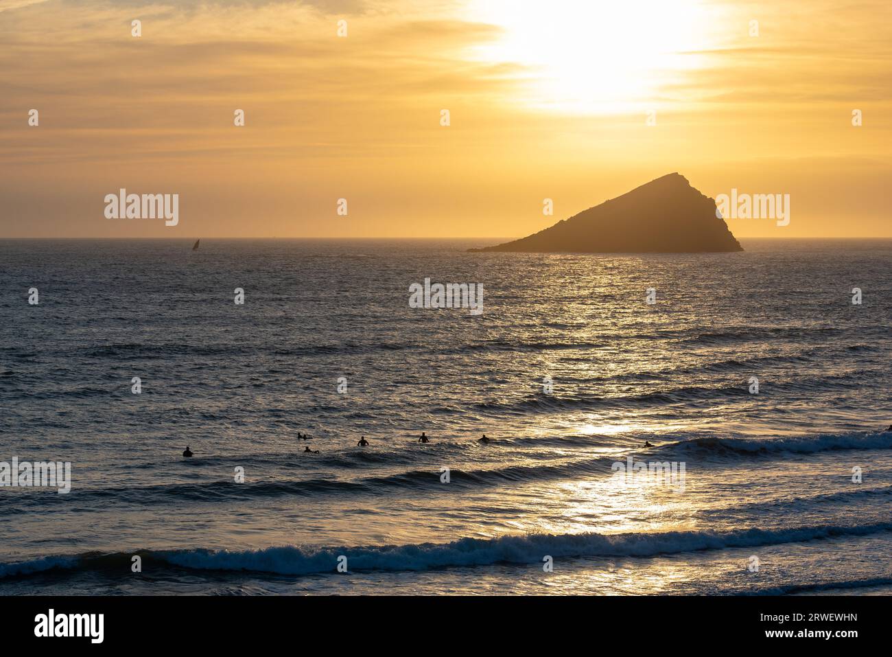 Sunset over the Great Mewstone with surfers in the foreground at ...