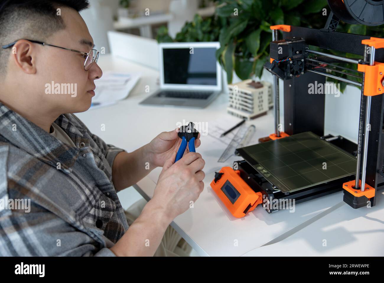 Asian designer engineer using 3D printer in laboratory and studying ...