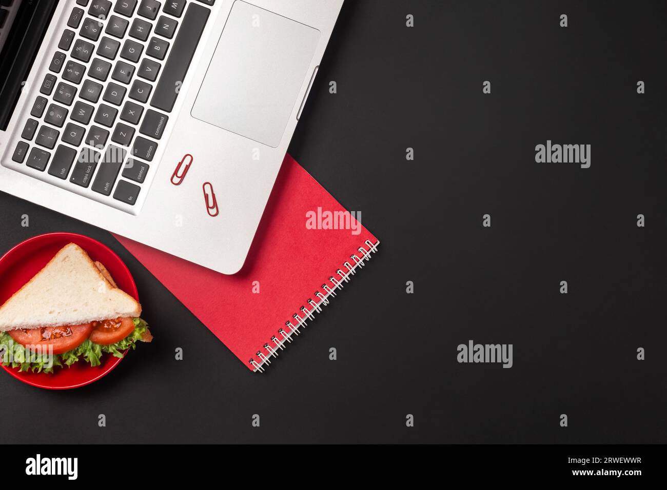 Elegant black office desktop with laptop and sandwich for lunch. Top ...