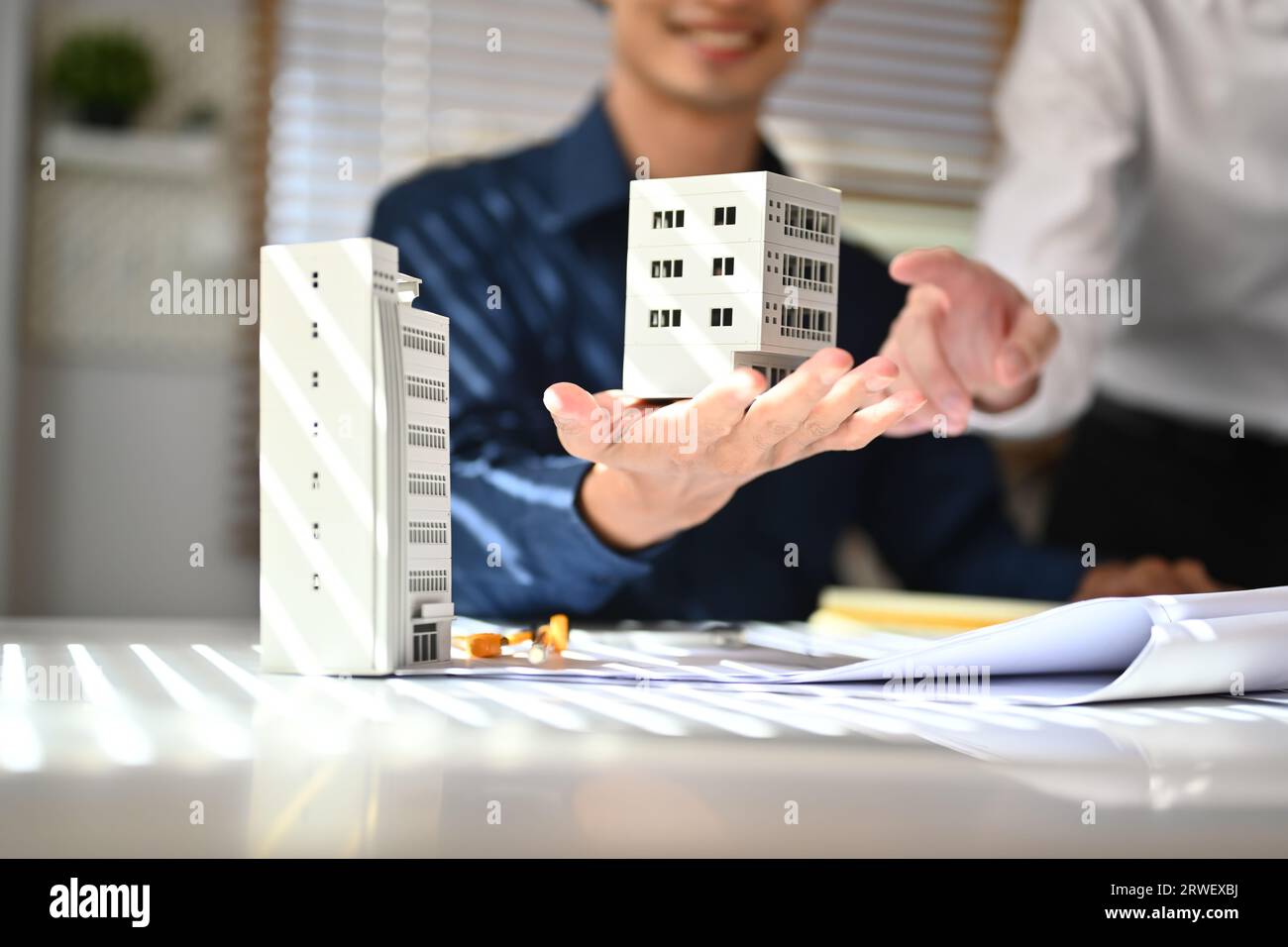 Architects team working on architectural model and discussing the new ...