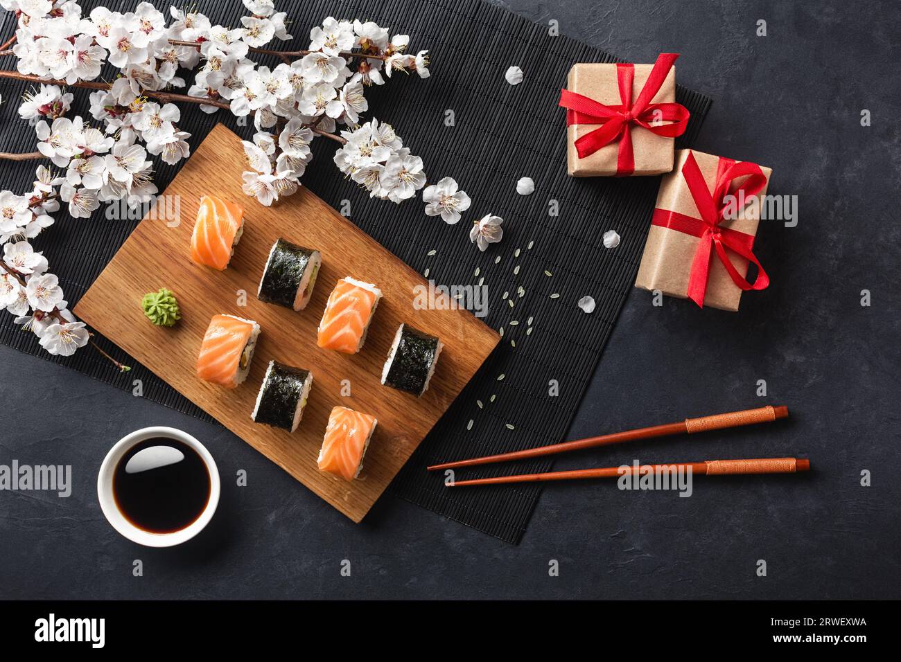 Set of sushi, maki rolls, gift boxes with branch of white flowers on stone table Top view Stock ...