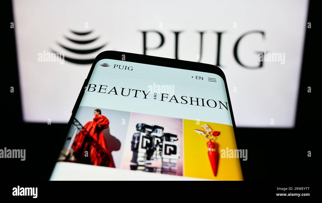 Smartphone with website of Spanish fashion and fragrance company Puig S.L. on screen in front of ...