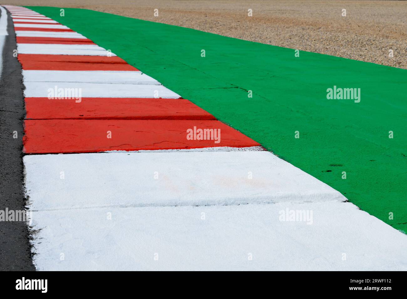 A race track red and white chevron, with a green run off before the ...