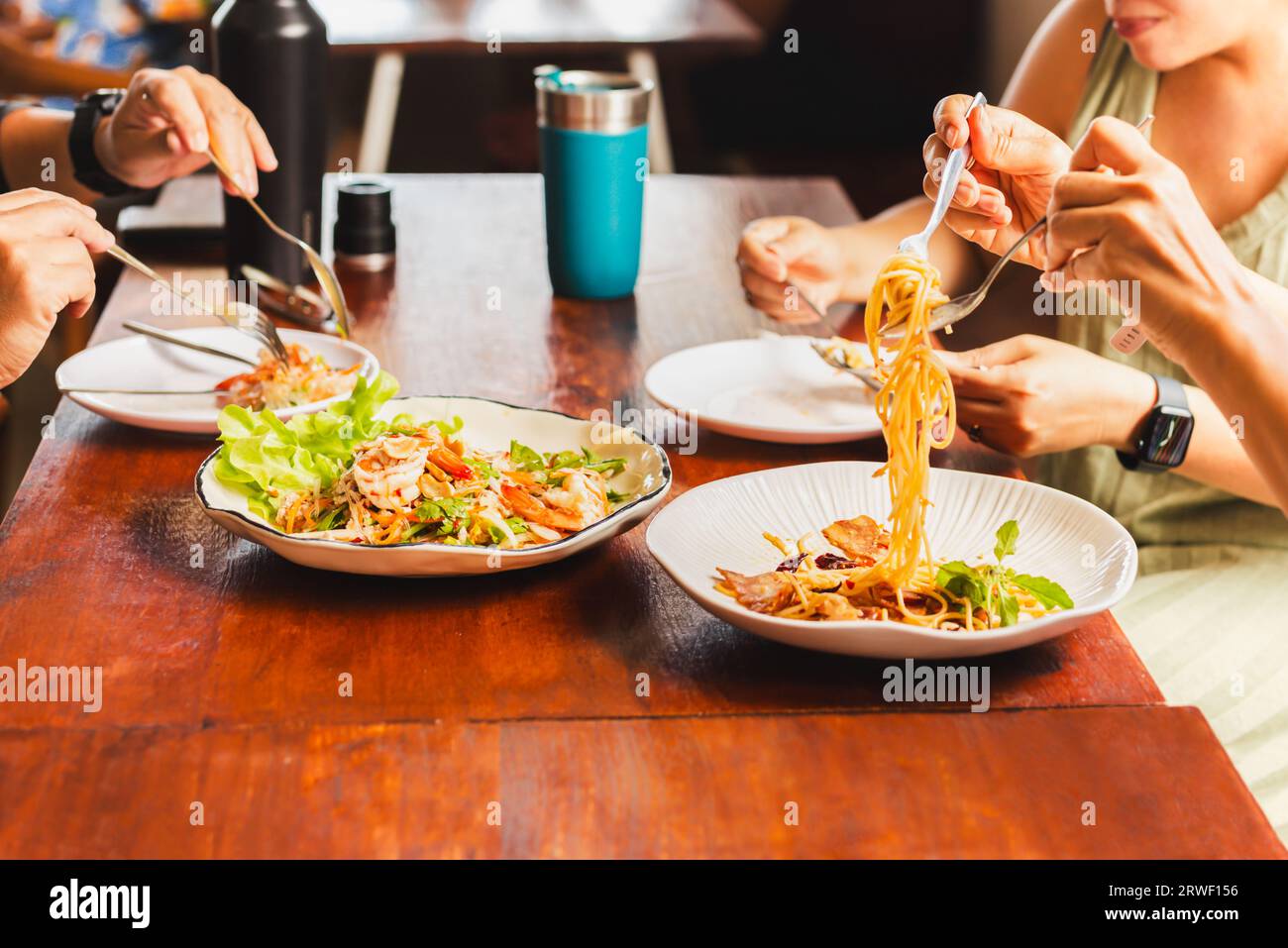 Family and friends eating spaghetti together in restaurant Stock Photo ...