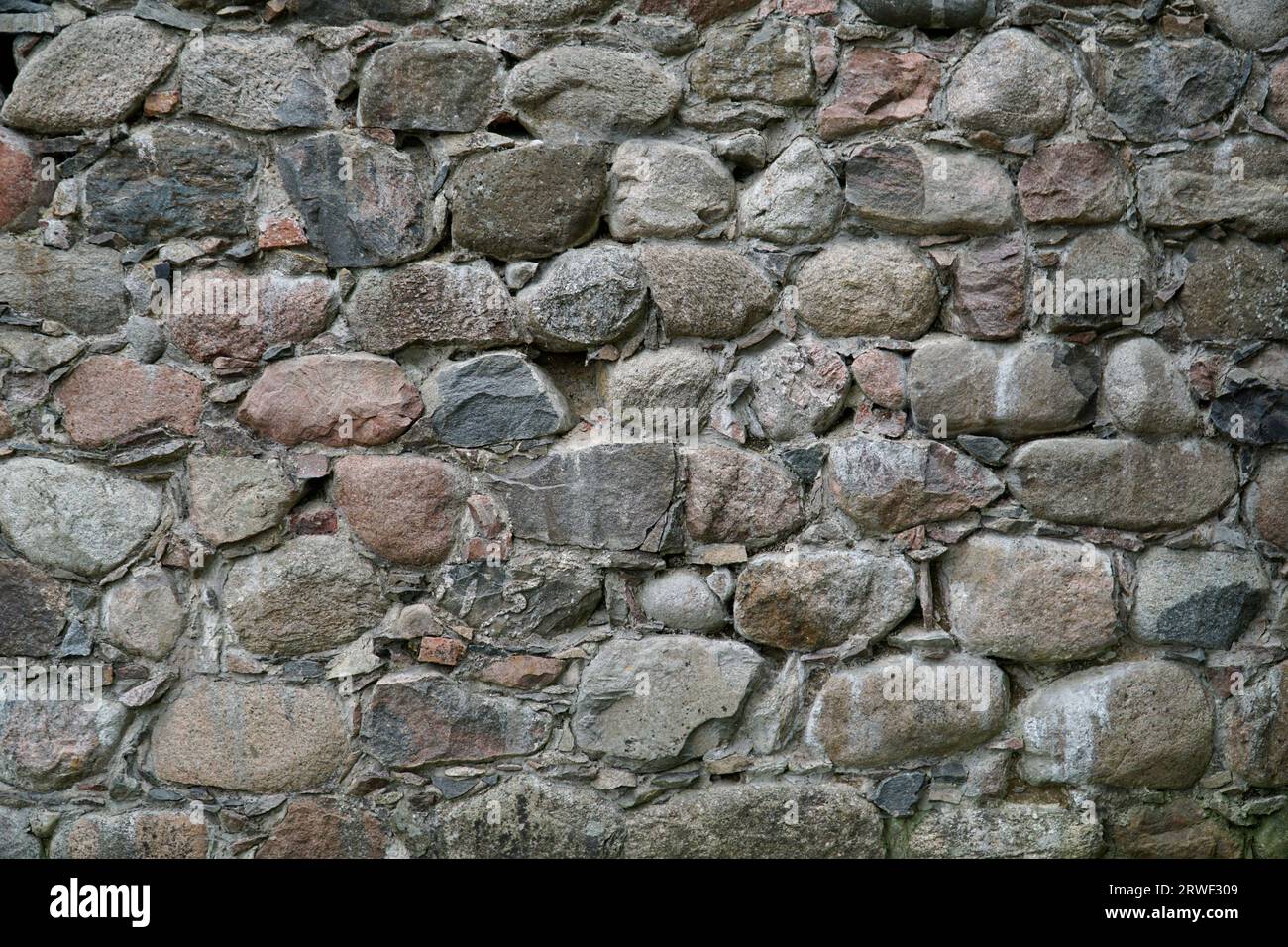 Wall made with round stones Stock Photo - Alamy