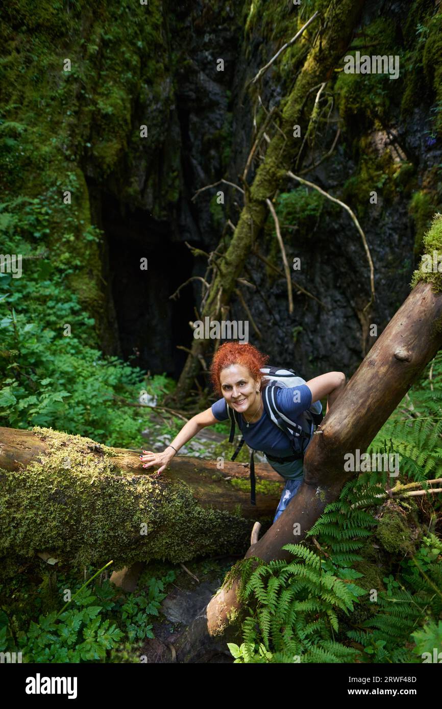 Woman hiker with backpack exploring a cave underground Stock Photo - Alamy