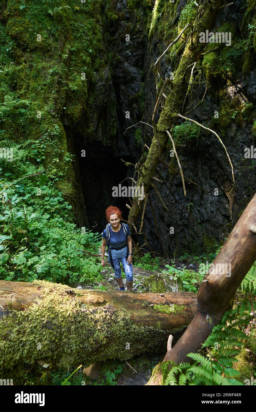 Woman hiker with backpack exploring a cave underground Stock Photo - Alamy