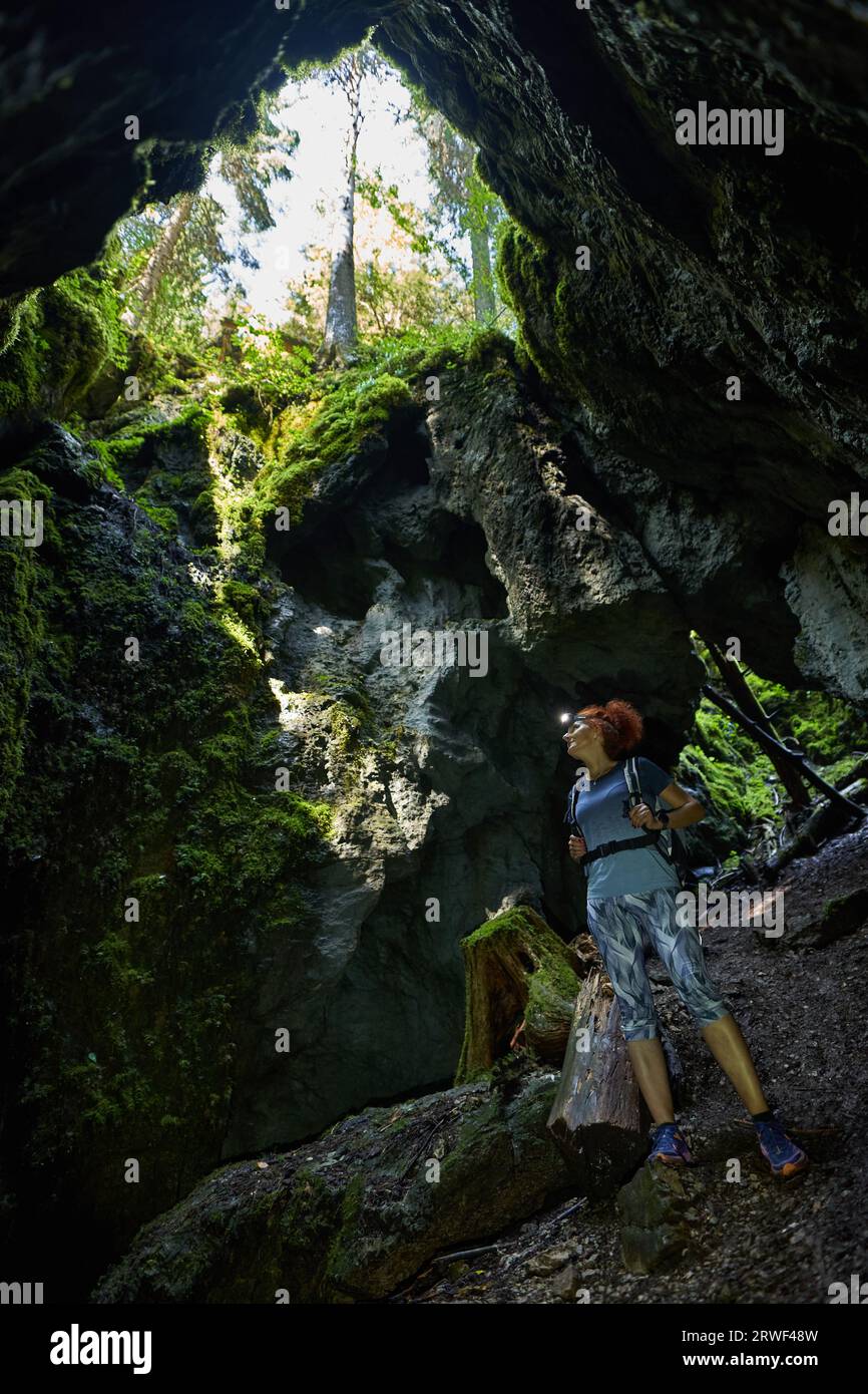 Woman hiker with backpack exploring a cave underground Stock Photo - Alamy