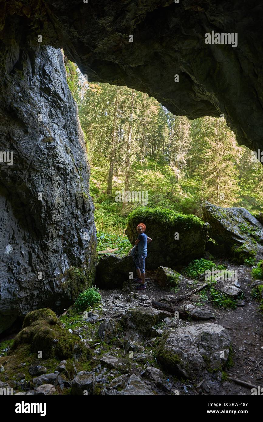 Woman hiker with backpack exploring a cave underground Stock Photo - Alamy