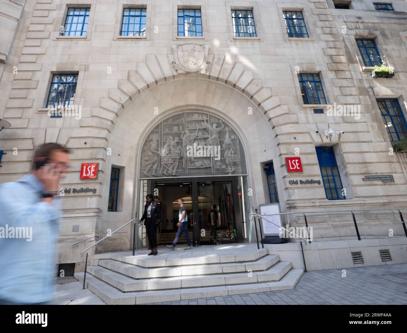 Old building part of the LSE London School of Economics campus Holborn London, with pedestrians ...