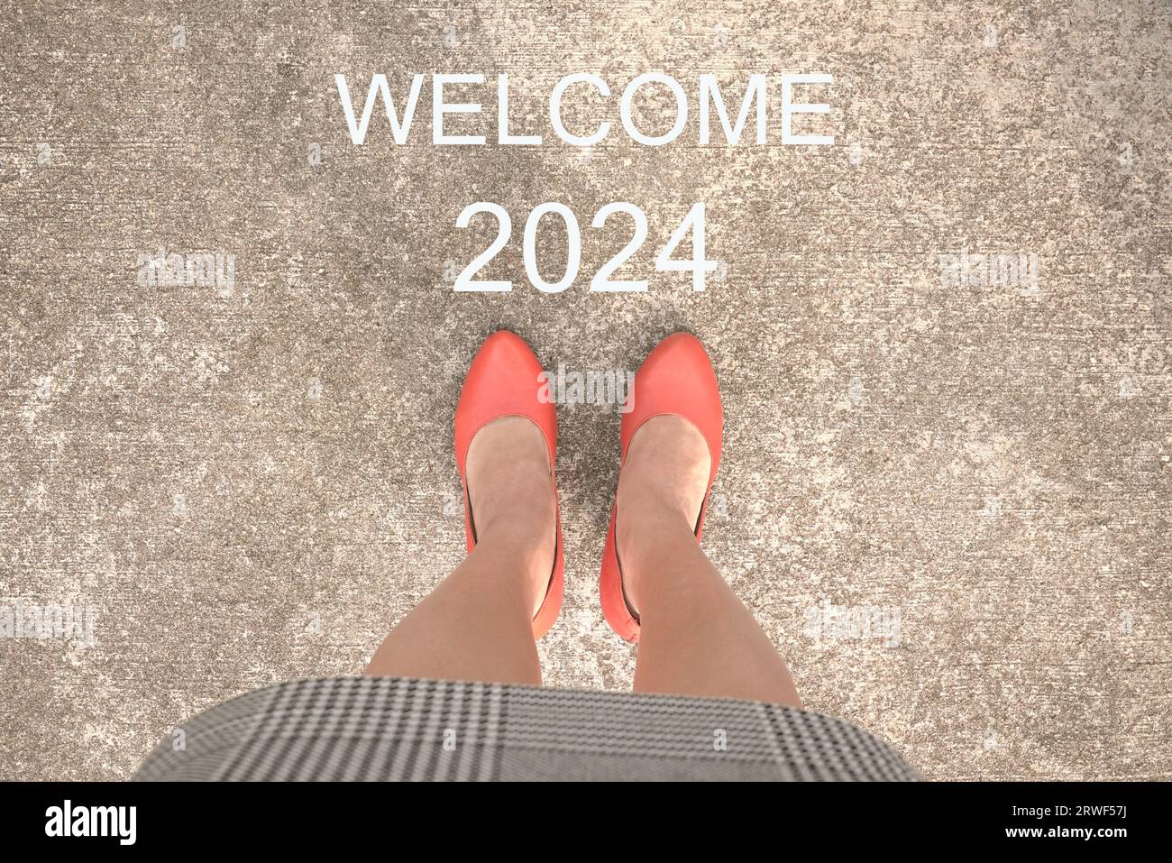 Welcome 2024 words on asphalt street with woman's feet. Top view ...