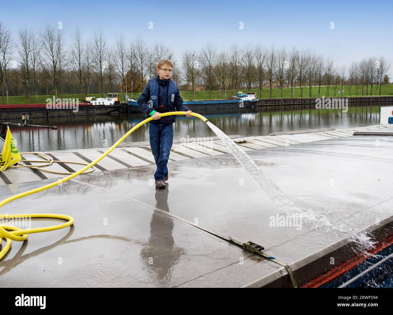 Young boy sprays the deck of a ship clean Netherlands 2014. vvbvanbree ...