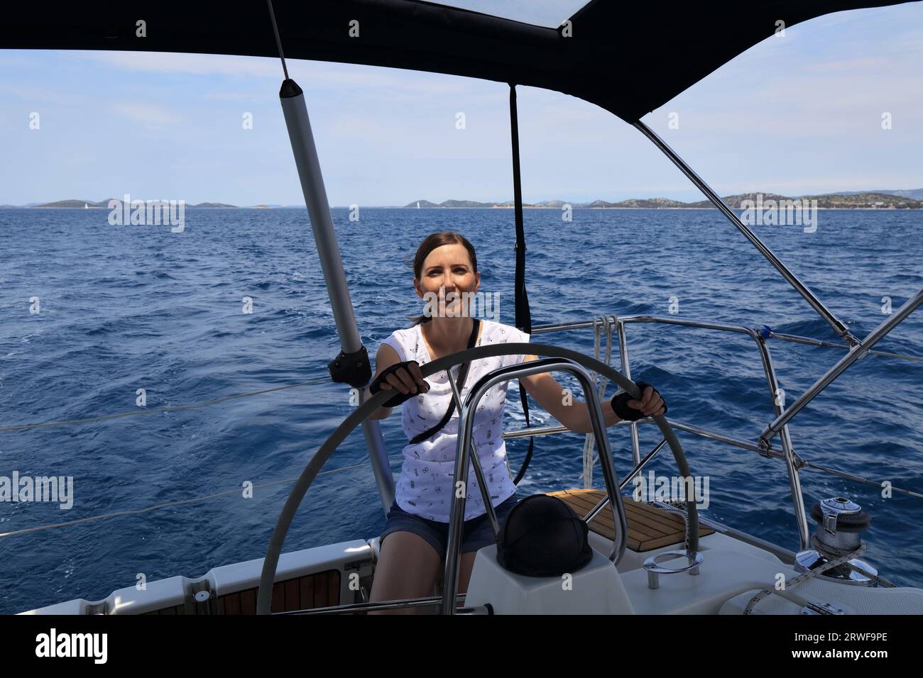 Woman at the helm of a sailing yacht in Croatia. Summer sailing ...