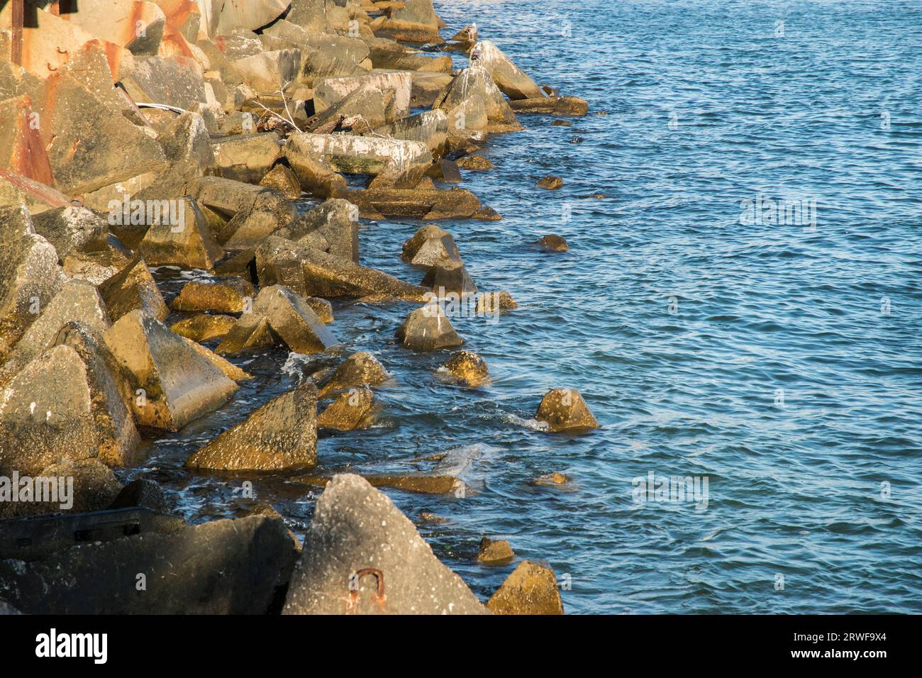 Coast breakwaters protecting from large waves with sea water closeup ...