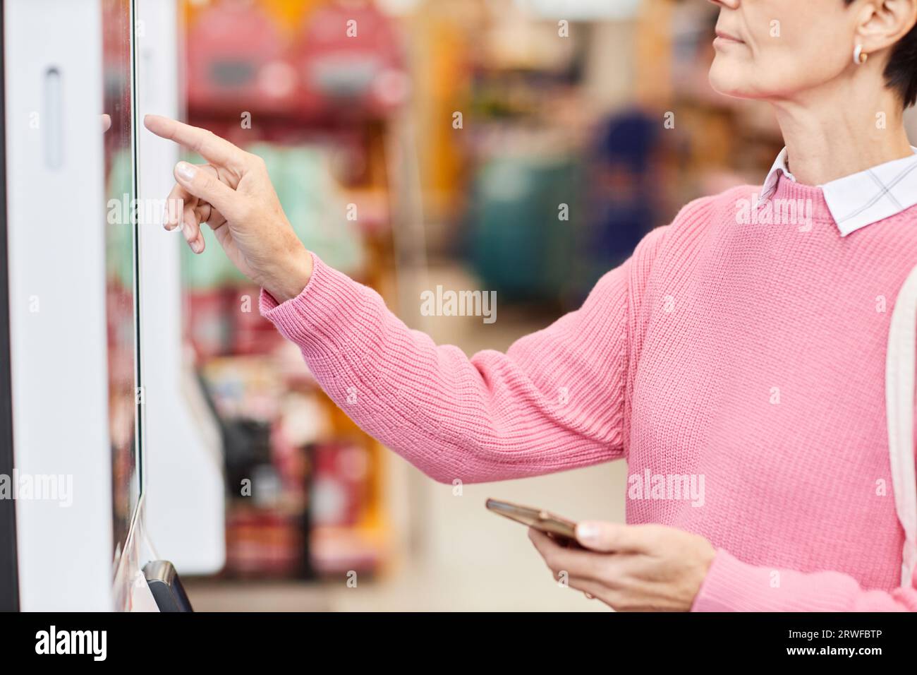 Side view closeup of woman tapping touch screen while buying groceries ...