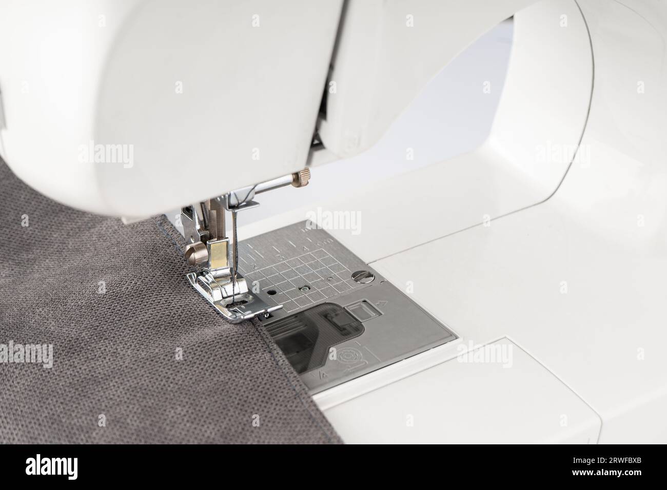 Modern sewing machine with gray fabric. Sewing process clothes ...