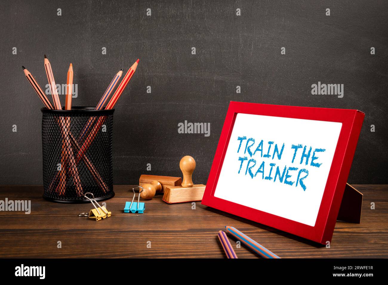Train The Trainer. A picture frame on a wooden office table Stock Photo ...
