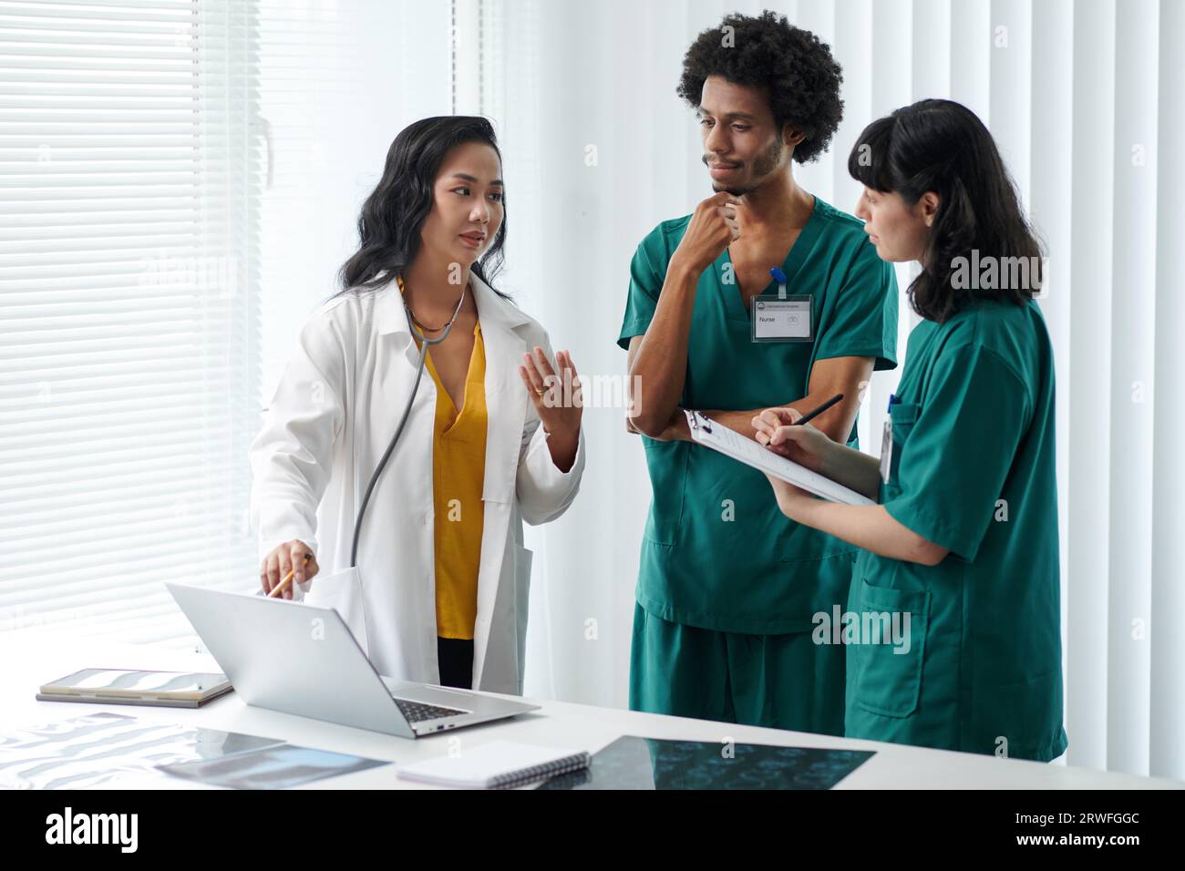 Doctor explaining nurses how to fill forms with results with xray ...