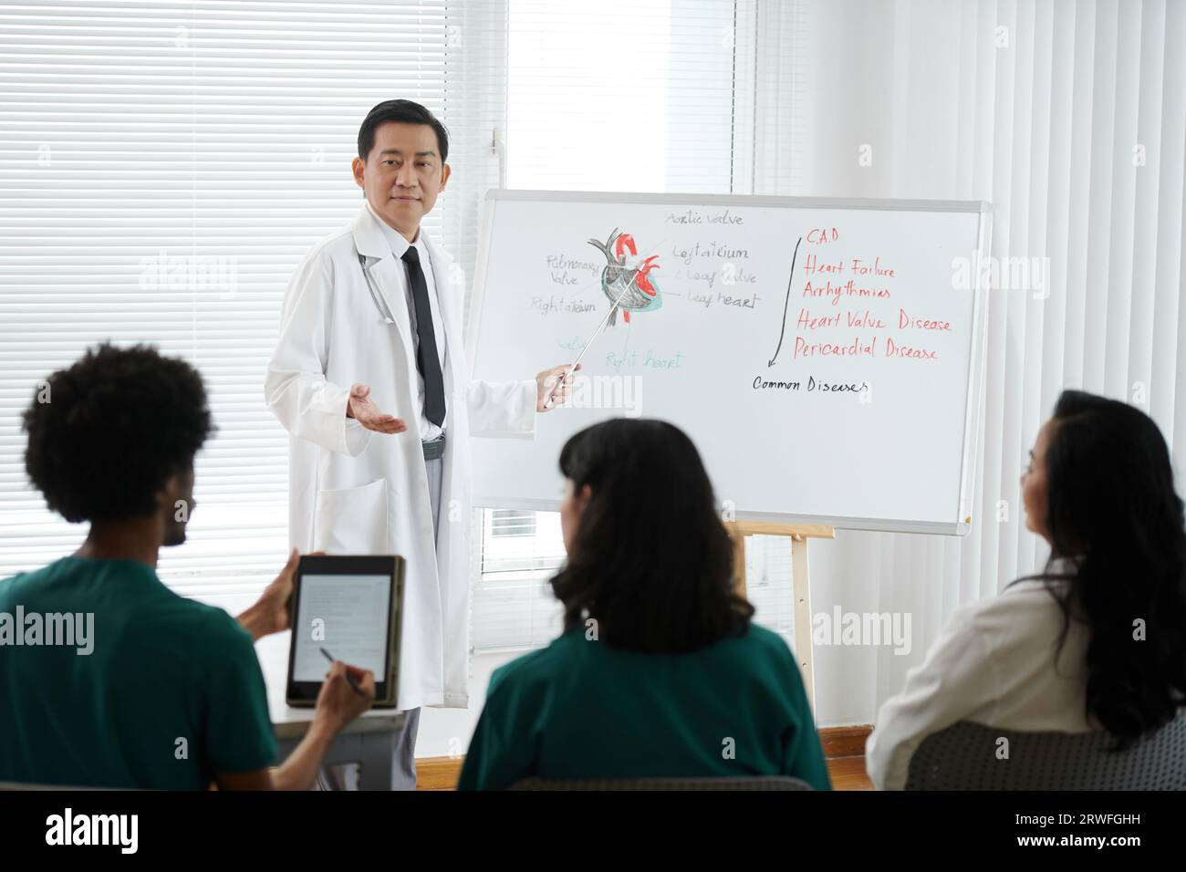 Medical academy professor teaching students how to treat heart disease Stock Photo - Alamy
