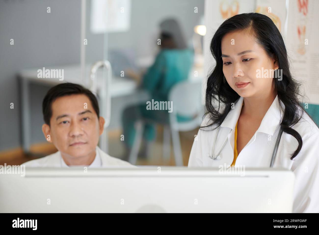 Team of doctors looking at computer screen with xray image Stock Photo ...