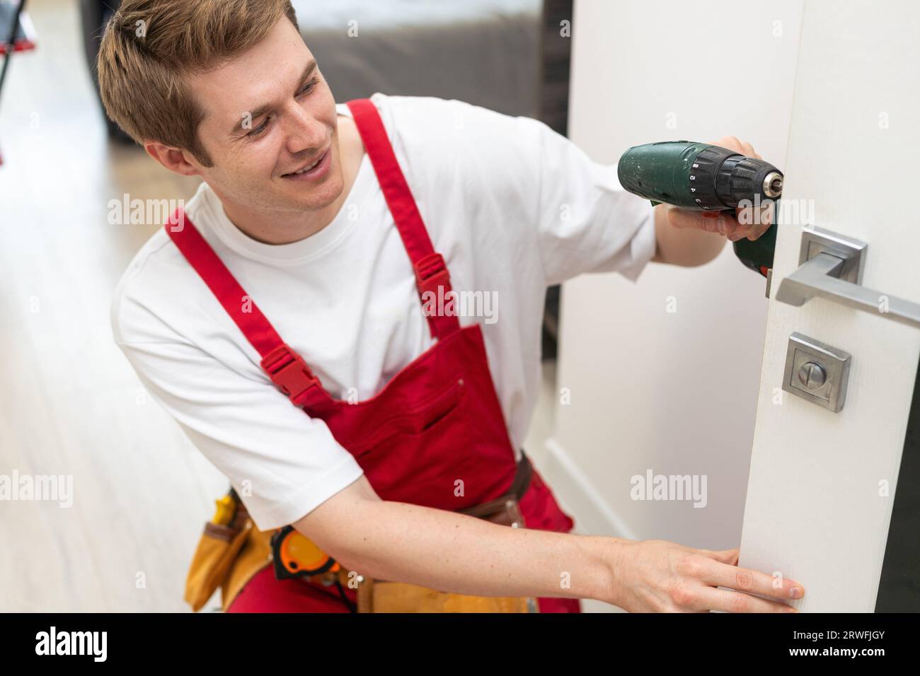 Installation of a lock on the front wooden entrance door. Portrait of ...