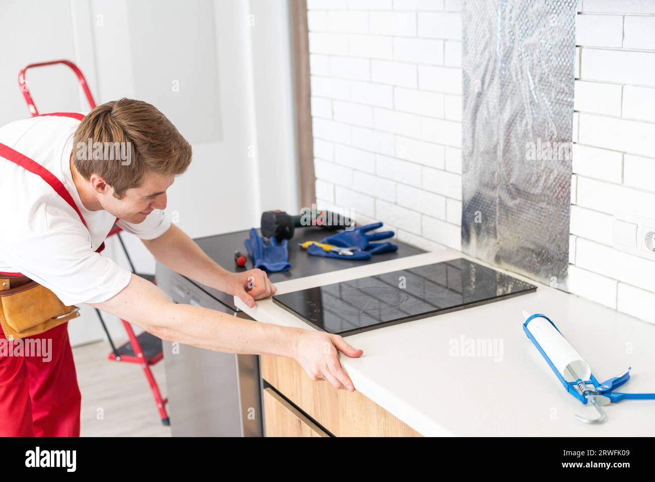 craftsman installs hob in kitchen. Household Appliance Installation ...
