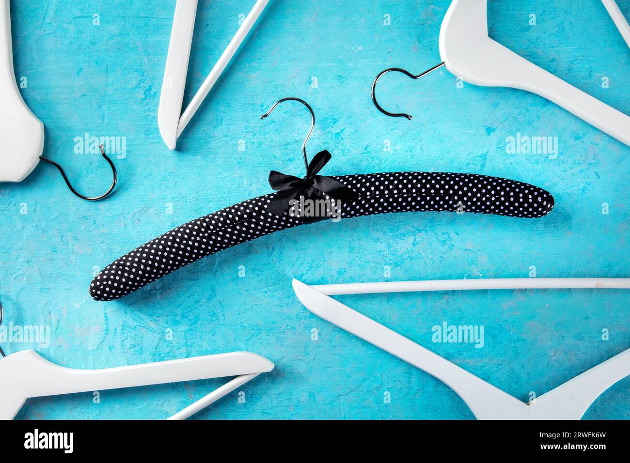 Exclusive fashion. Black satin hanger for delicate clothes surrounded ...