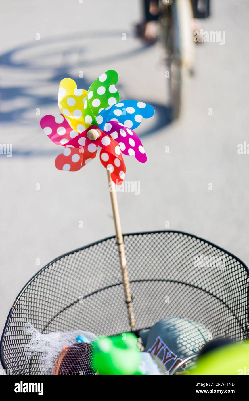 Colorful pinwheel attached to bicycle basket to entertain toddler child ...