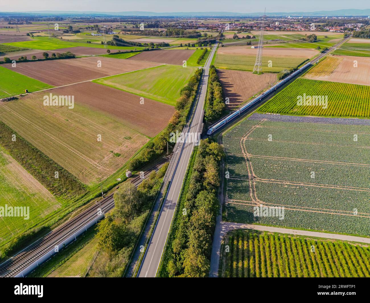 ICE express train on railroad line in rural area and bridge with cars ...