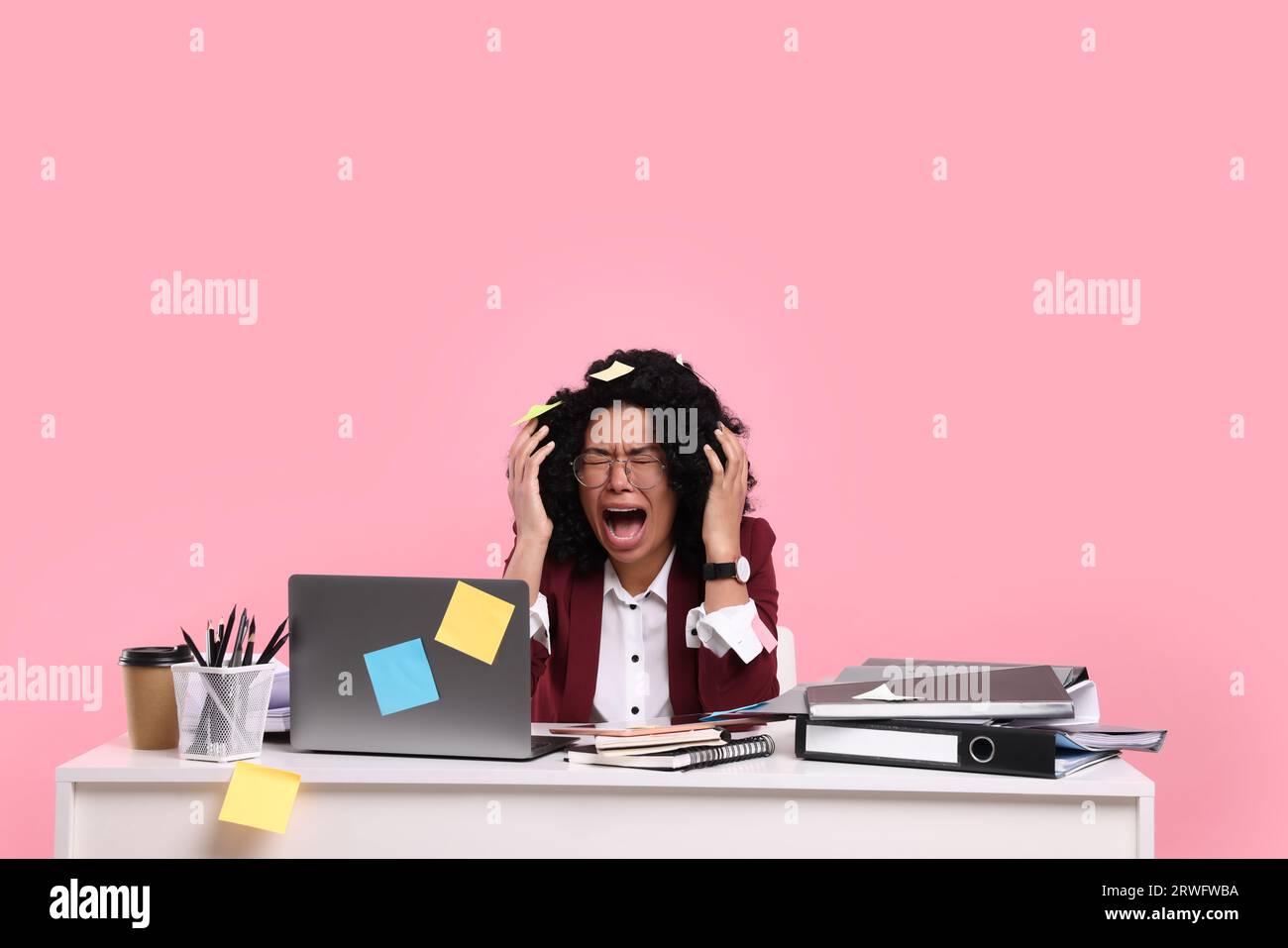 Stressful deadline. Screaming woman at white desk against pink ...