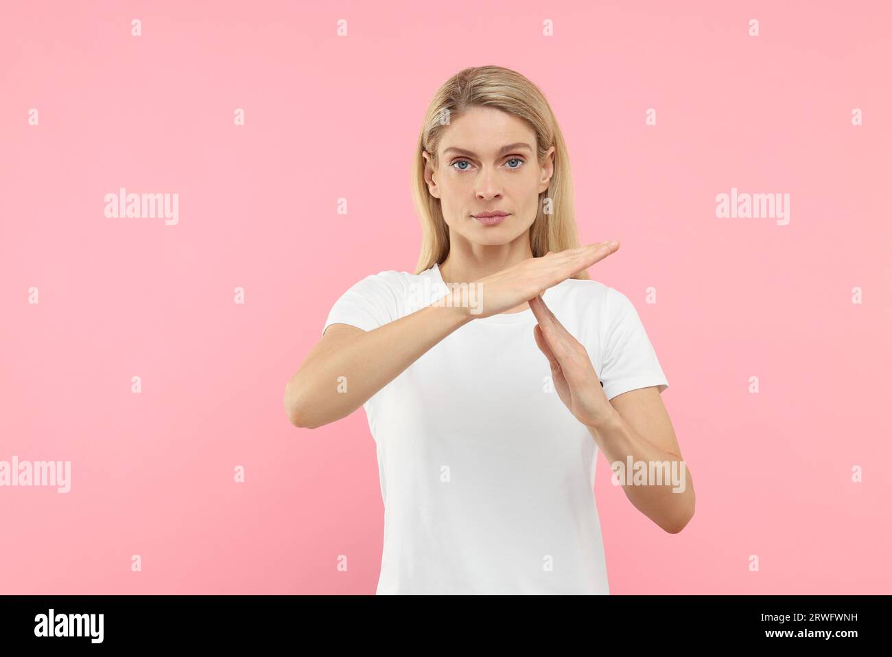 Woman showing time out gesture on pink background. Stop signal Stock ...