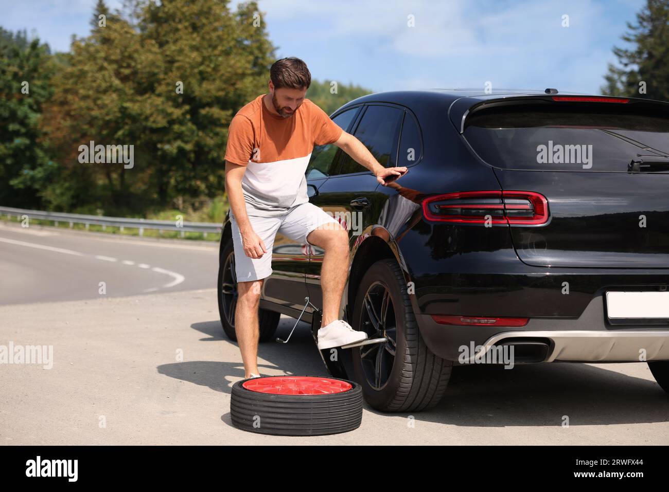 Man changing wheel of car on roadside outdoors Stock Photo - Alamy
